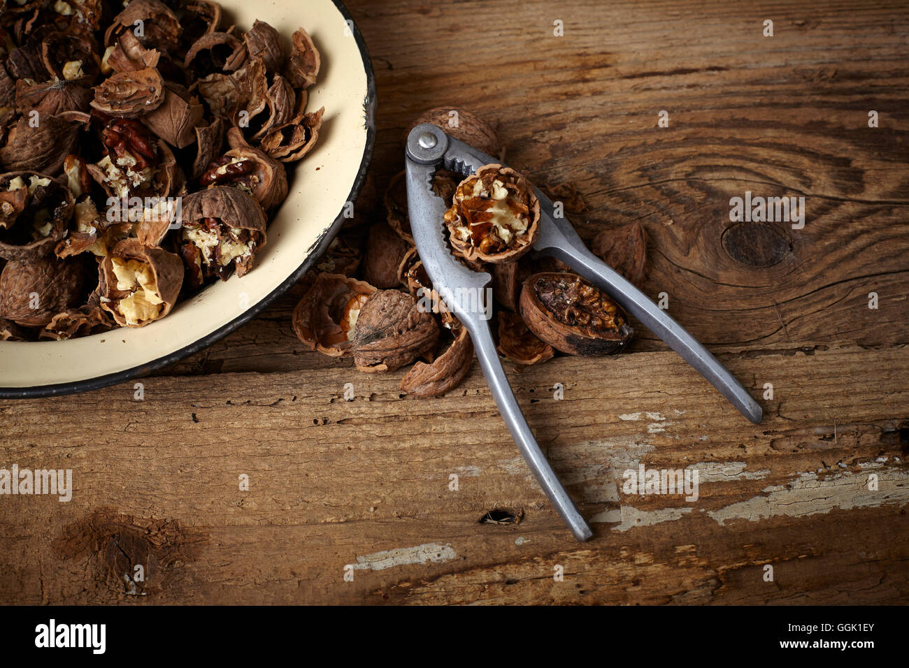 walnuts cracked open with old nut cracker in a vintage plate on a ...