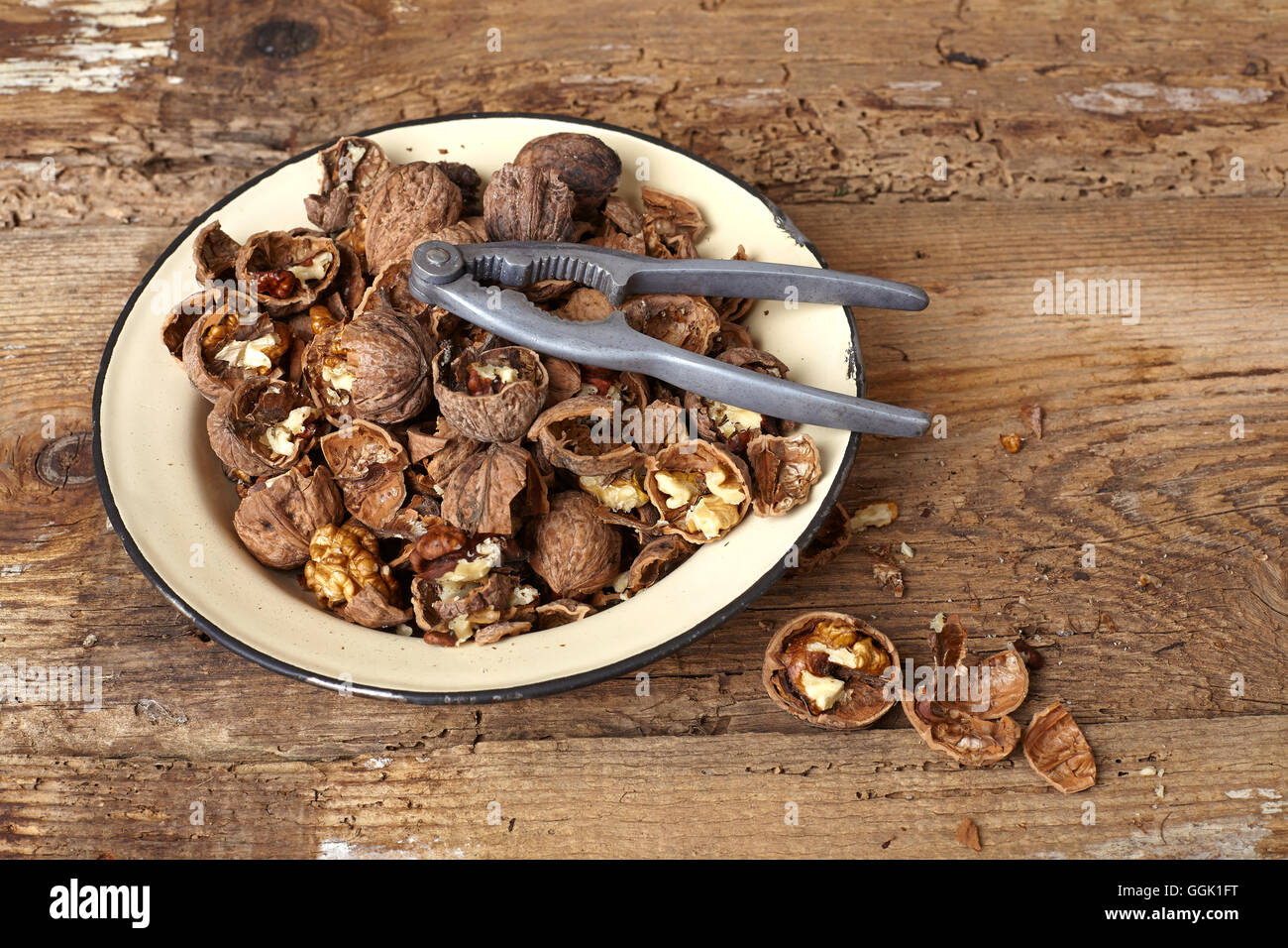 walnuts cracked open with old nut cracker in a vintage plate on a ...
