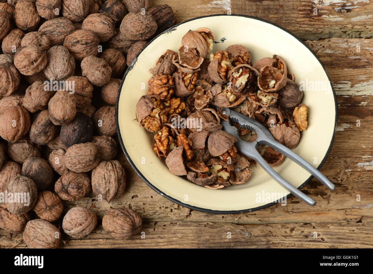 walnuts cracked open with old nut cracker in a vintage plate on a wooden table Stock Photo - Alamy