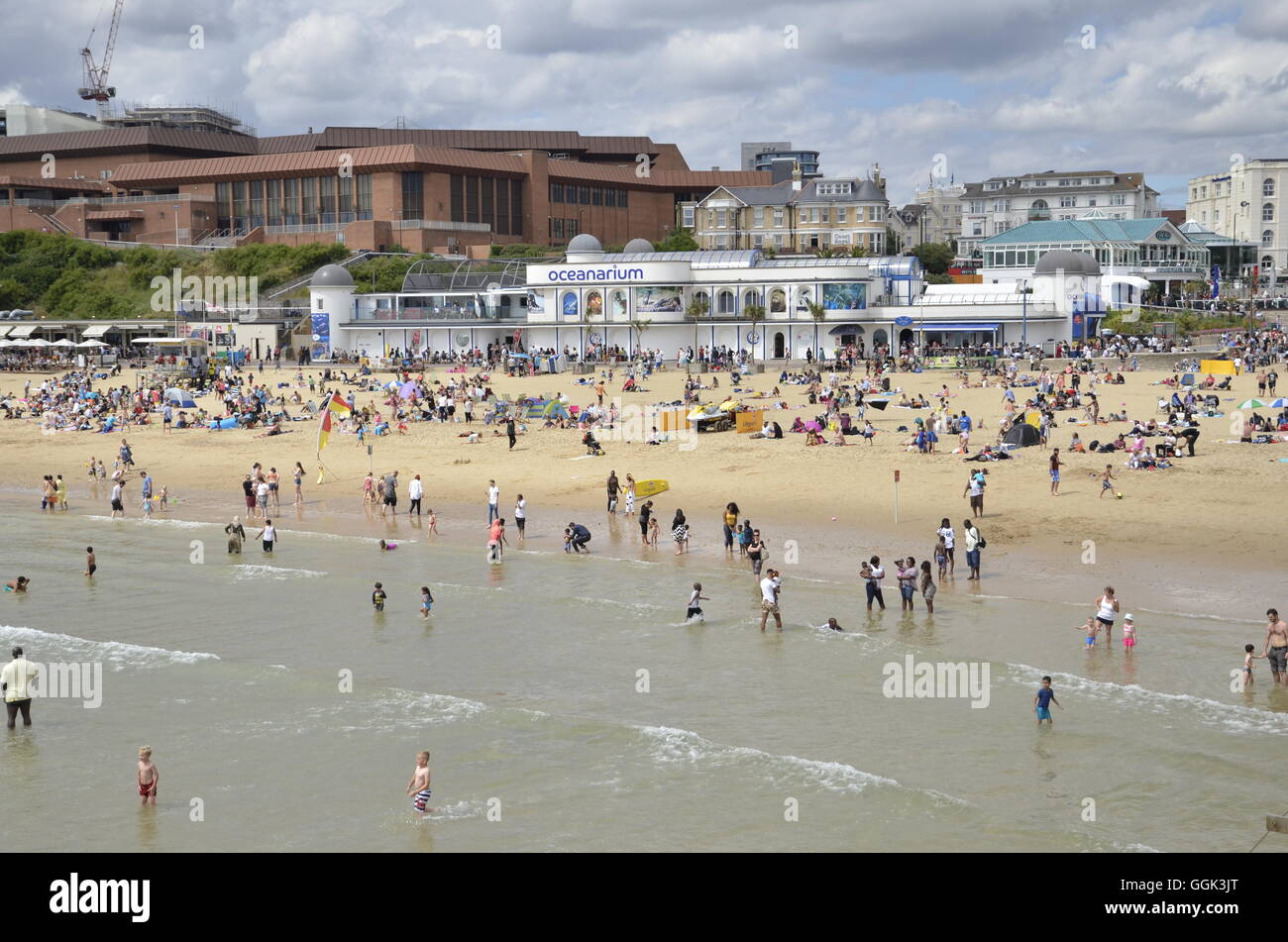 Holidaymakers and tourists enjoying summer sun on the beach at ...