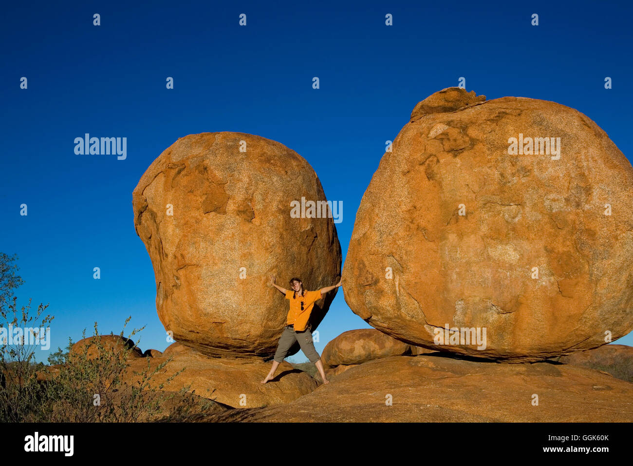 Woman standing inbetween two of the round red rocks called Devils ...