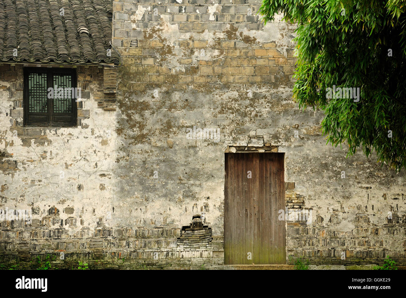 A wooden doorway leading into a weathered stone building within Wuzhen ...