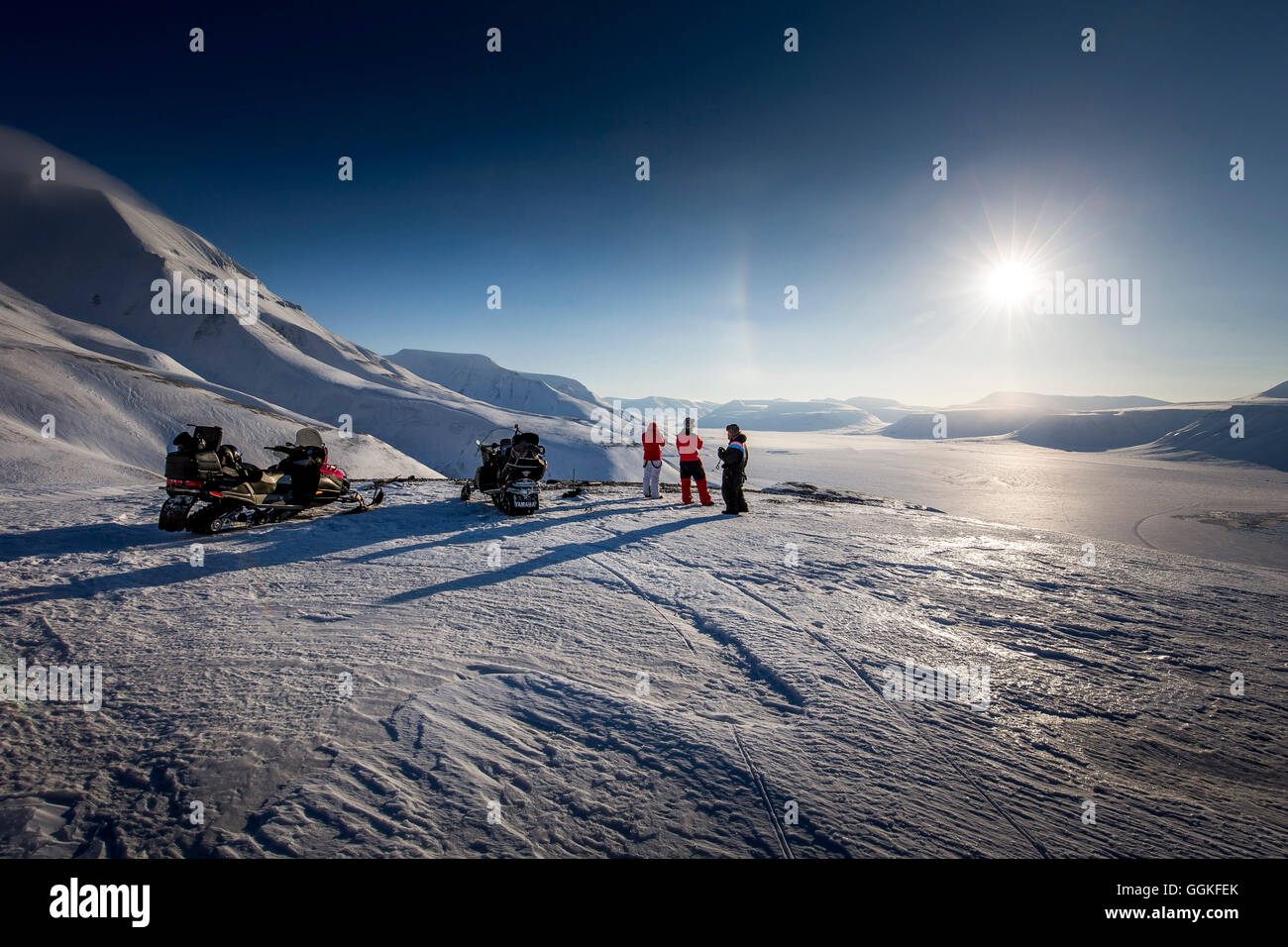 People in the snowy landscape of Spitzbergen with snowmobiles ...