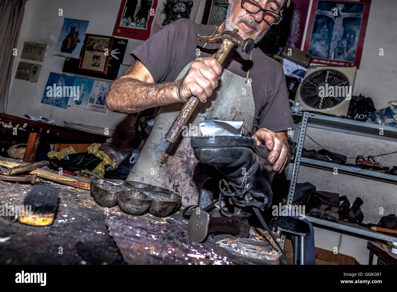 adult male shoemender working at his own workshop Stock Photo - Alamy