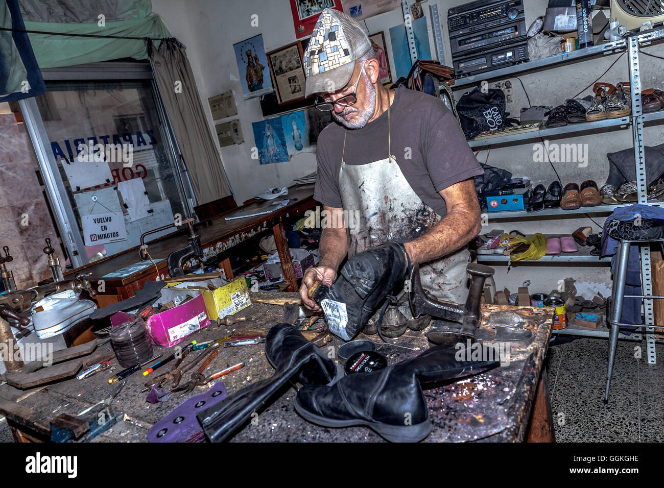 adult male shoemender working at his own workshop Stock Photo - Alamy