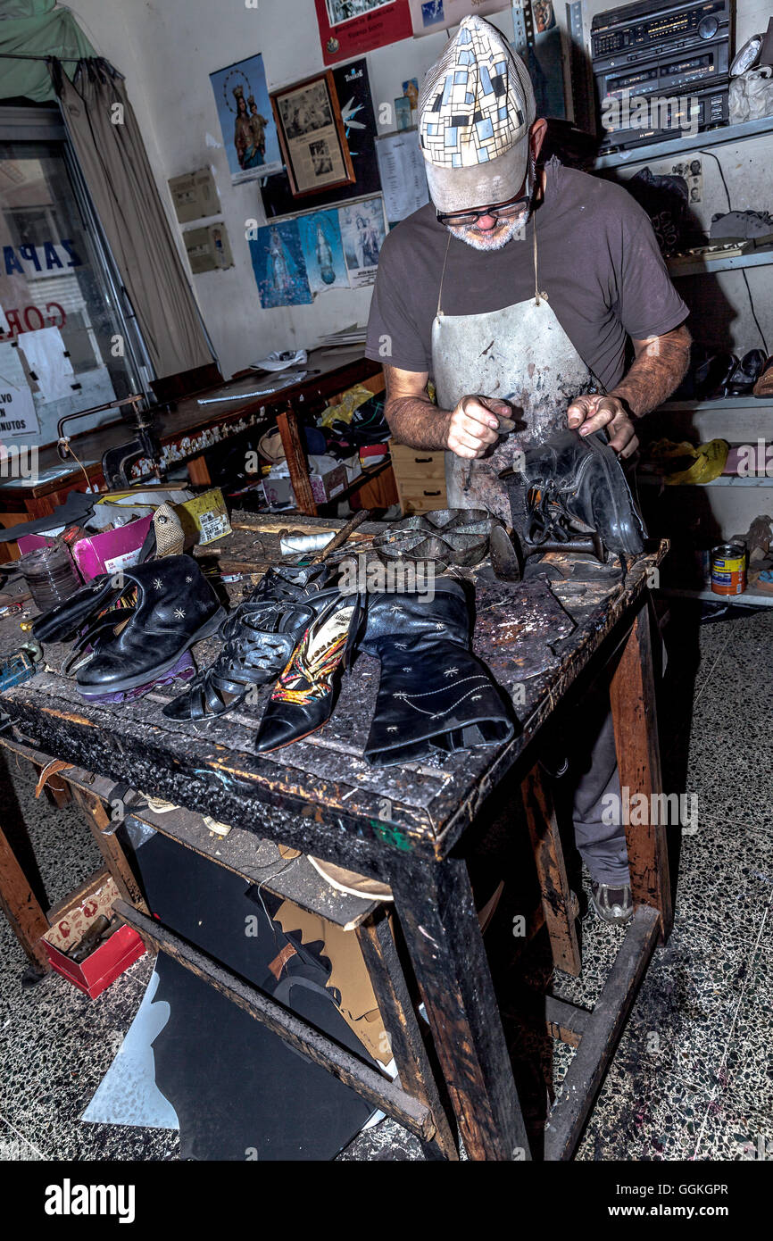 adult male shoemender working at his own workshop Stock Photo - Alamy