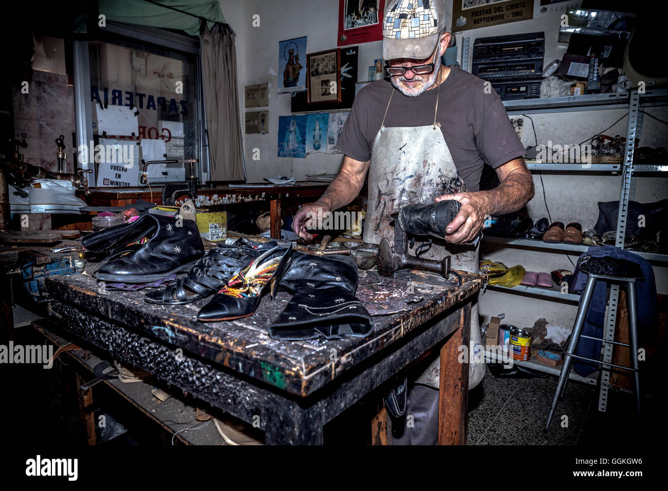 adult male shoemender working at his own workshop Stock Photo - Alamy