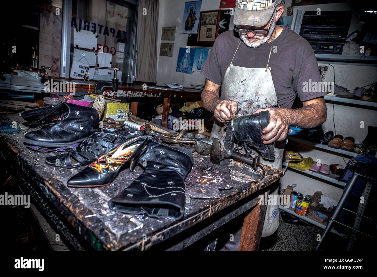 adult male shoemender working at his own workshop Stock Photo - Alamy