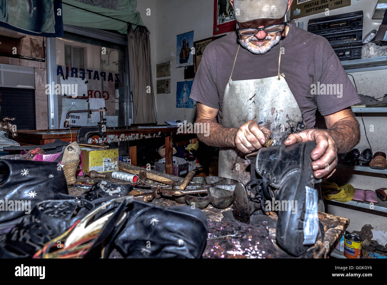 adult male shoemender working at his own workshop Stock Photo - Alamy