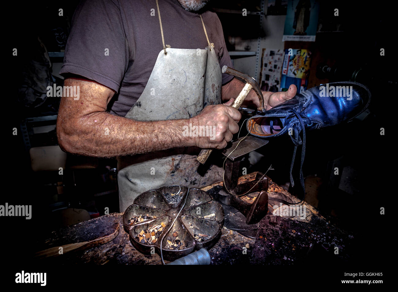 adult male shoemender working at his own workshop Stock Photo - Alamy