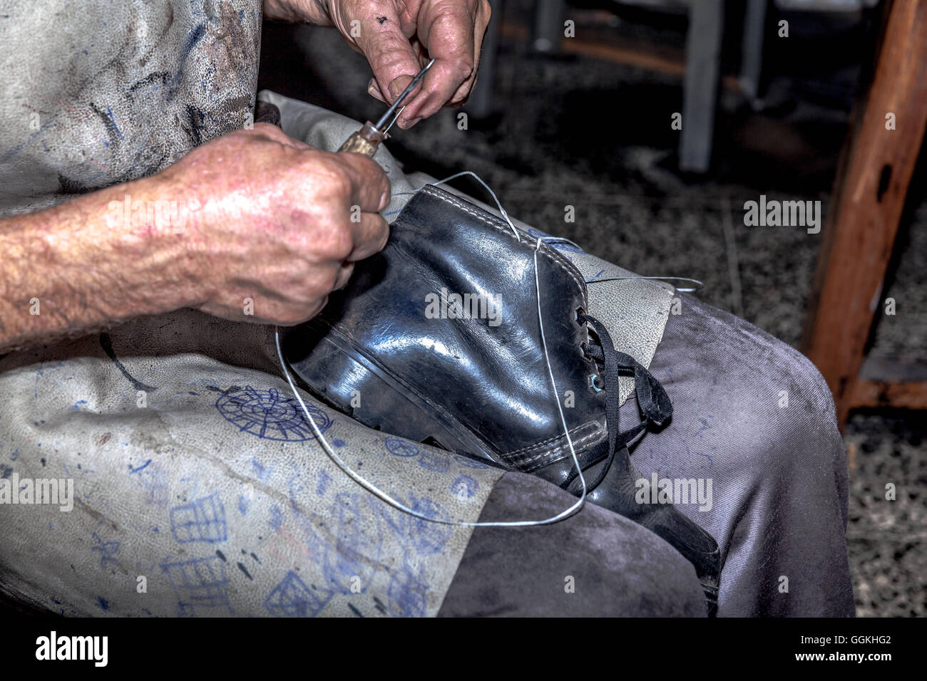 adult male shoemender working at his own workshop Stock Photo - Alamy