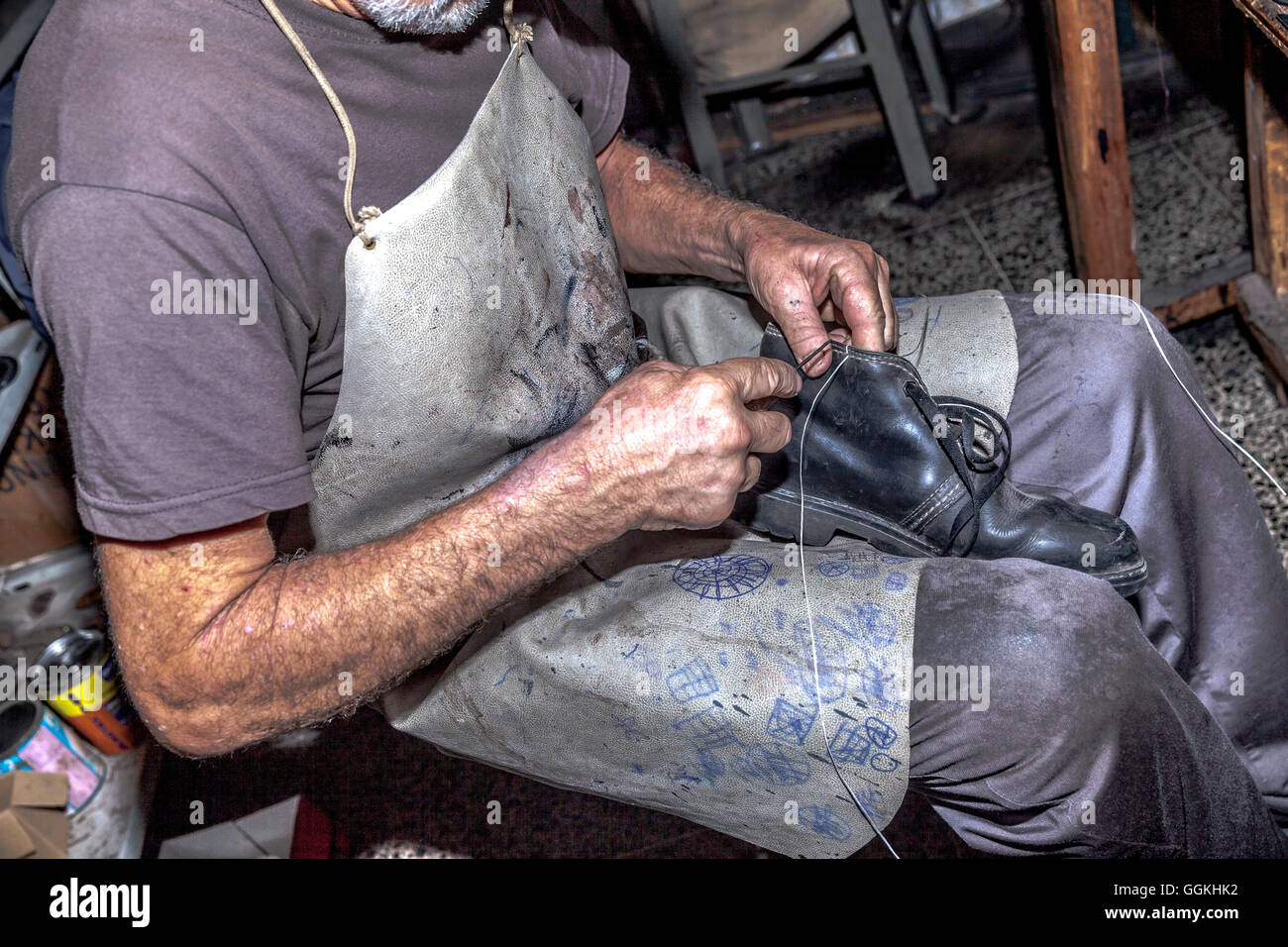 adult male shoemender working at his own workshop Stock Photo - Alamy
