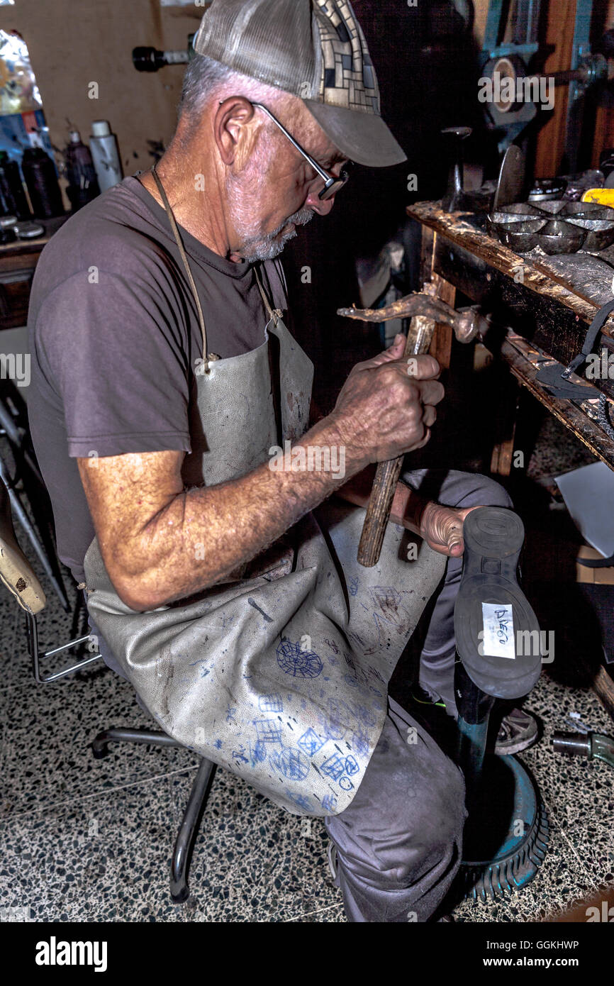 adult male shoemender working at his own workshop Stock Photo - Alamy