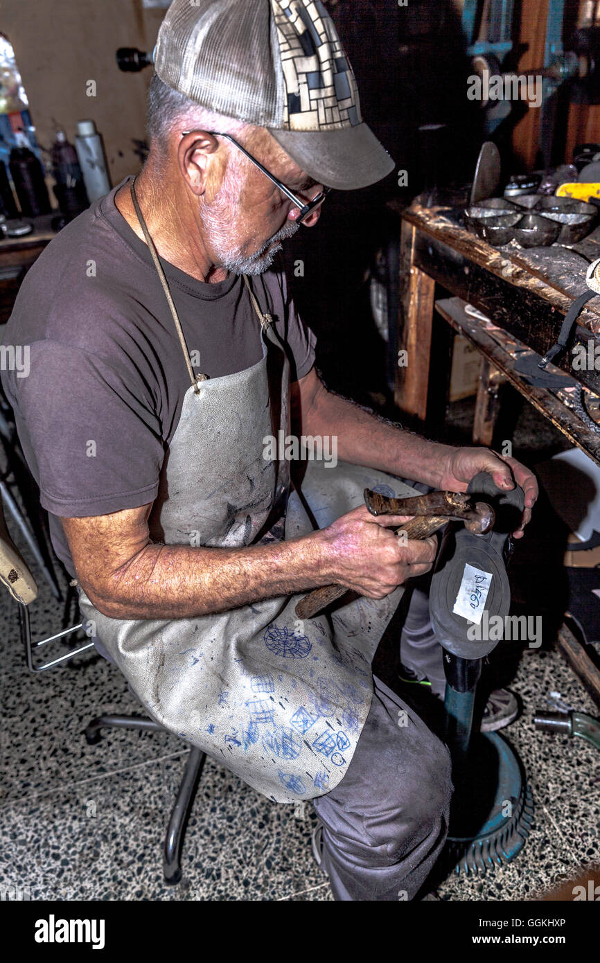 adult male shoemender working at his own workshop Stock Photo - Alamy