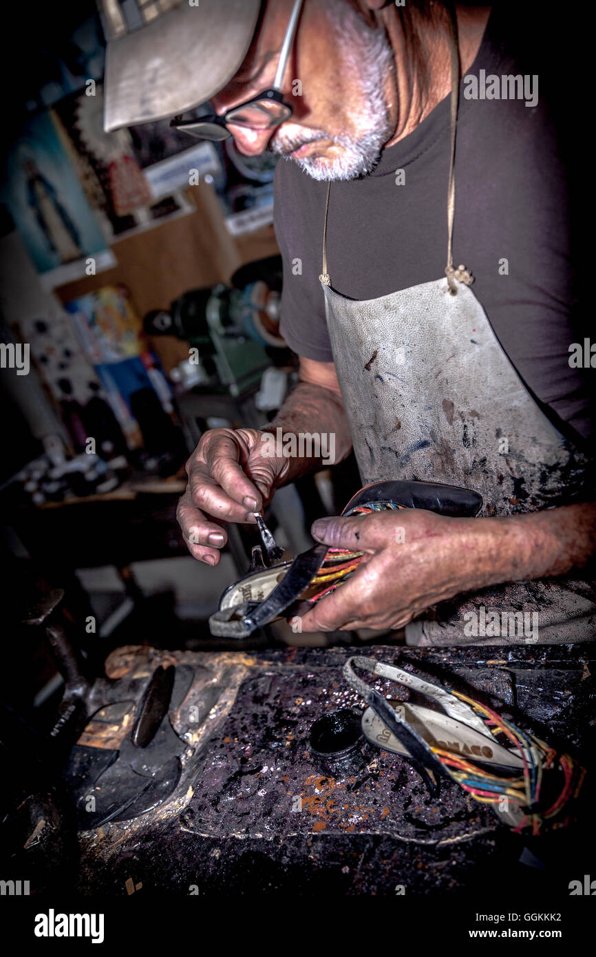adult male shoemender working at his own workshop Stock Photo - Alamy
