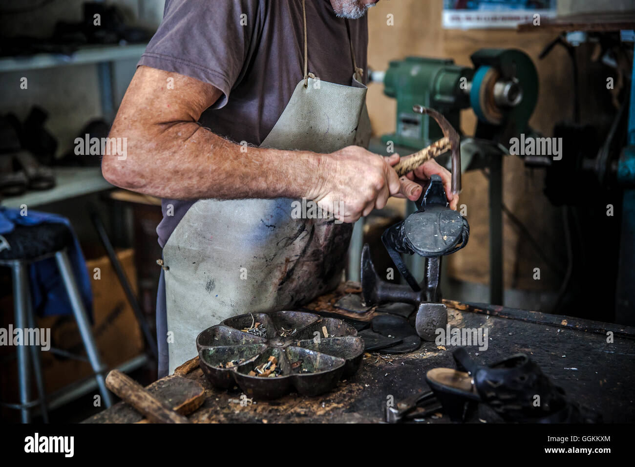 adult male shoemender working at his own workshop Stock Photo - Alamy