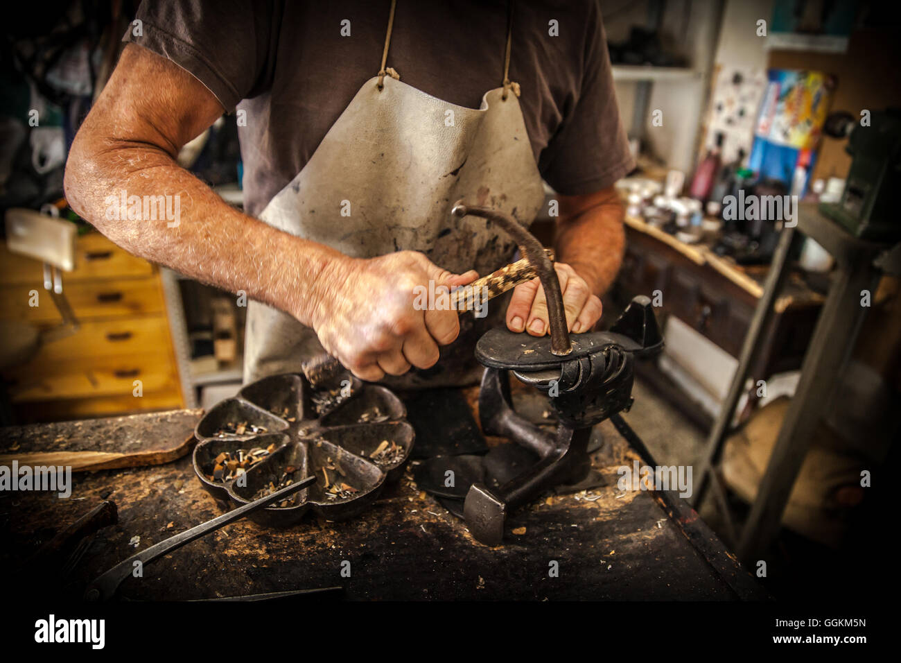 adult male shoemender working at his own workshop Stock Photo - Alamy