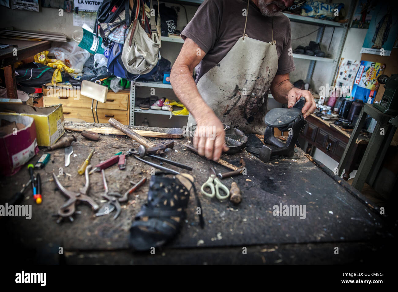 adult male shoemender working at his own workshop Stock Photo - Alamy