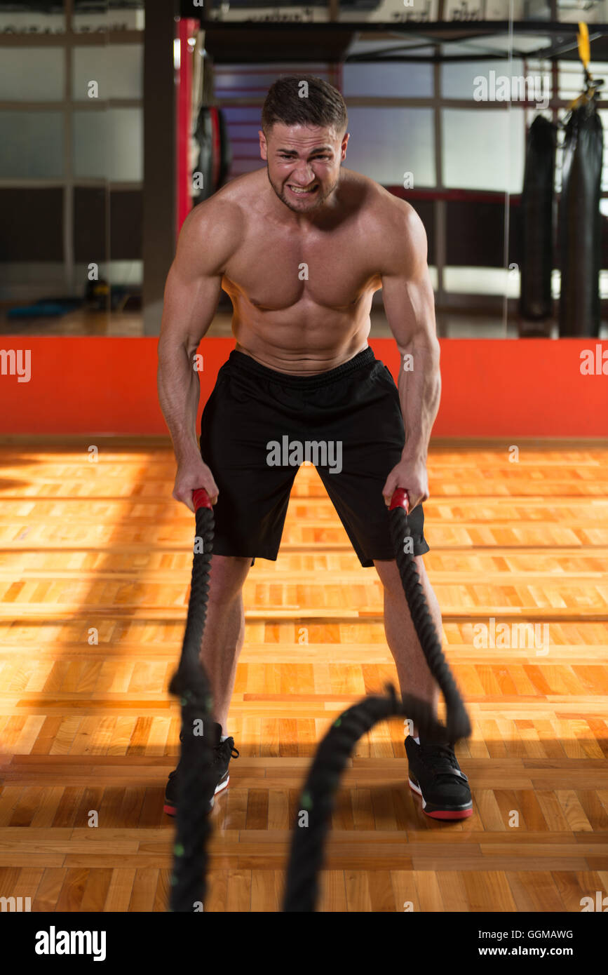 Battling Ropes Young Man At Gym Workout Exercise Stock Photo - Alamy