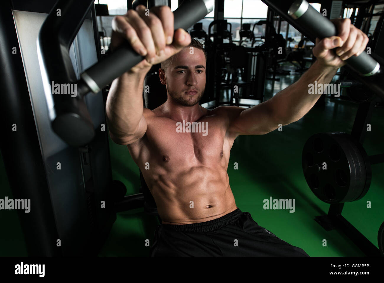 Young Bodybuilder Doing Heavy Weight Exercise For Chest On Machine ...