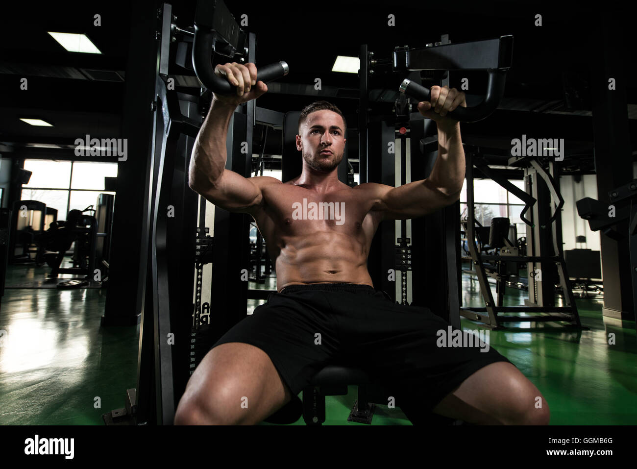 Young Bodybuilder Doing Heavy Weight Exercise For Chest On Machine ...
