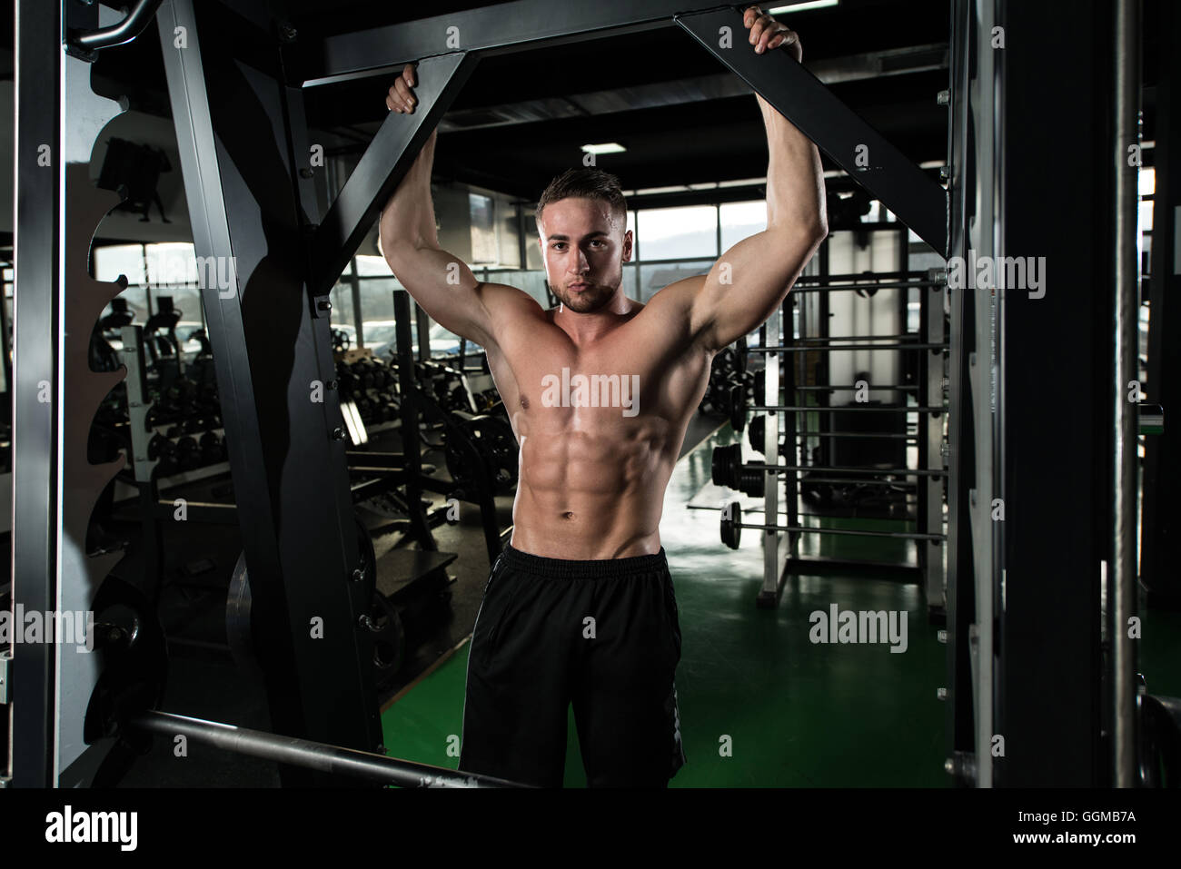 Young Man Standing Strong In The Gym And Flexing Muscles - Muscular ...