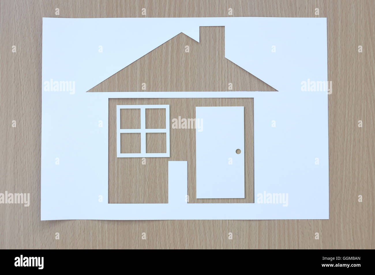 Paper shaped house on a background of brown wood,Ideas for the design ...