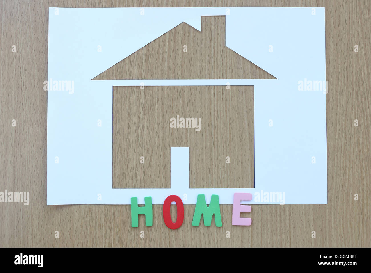 Paper shaped house on a background of brown wood and Craftsman tool ...