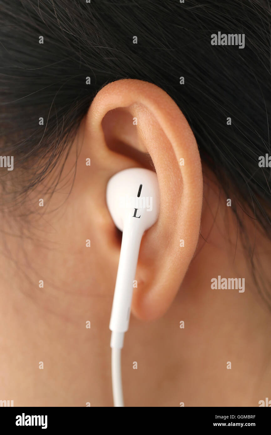 White headset in the ear of the woman in the near term,left side Stock ...