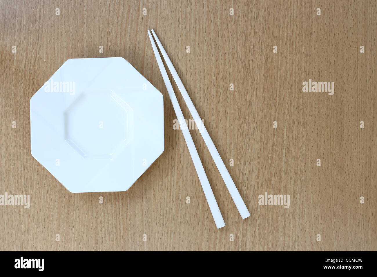 White chopsticks and dish in top view on wood background for design ...