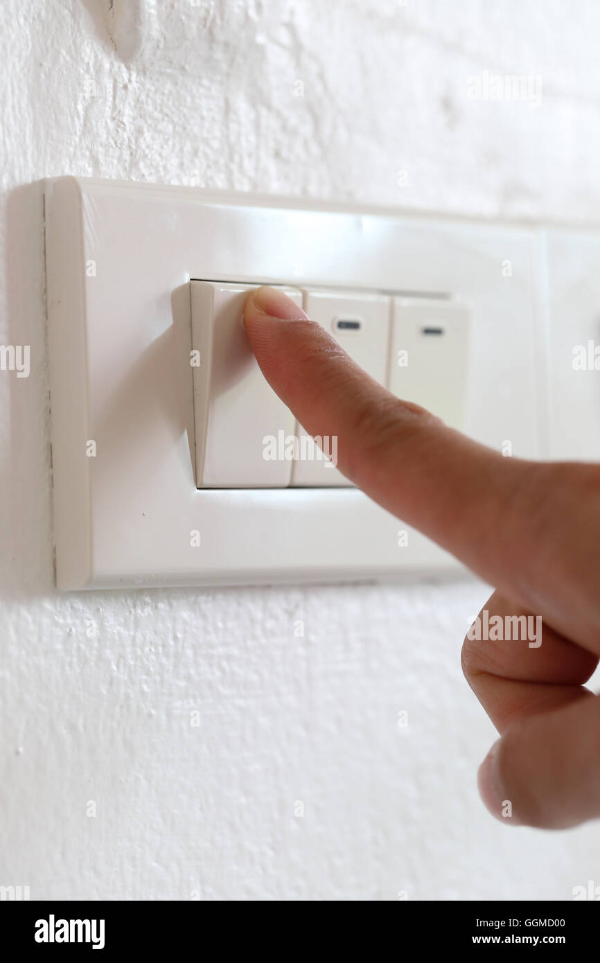 fingers are off light switch in the house,concept for energy saving ...
