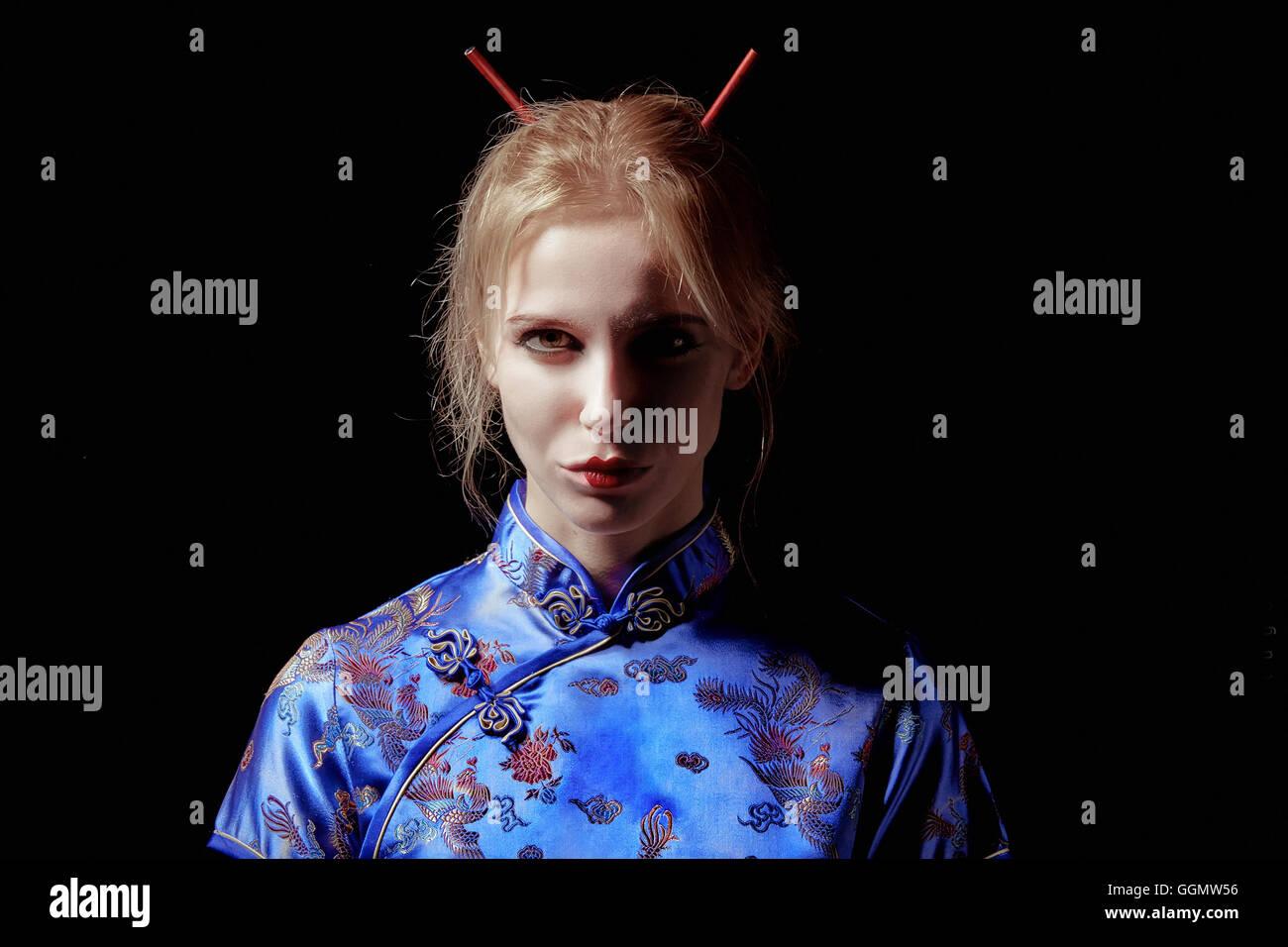 serious sad girl in geisha costume looking at camera on black ...