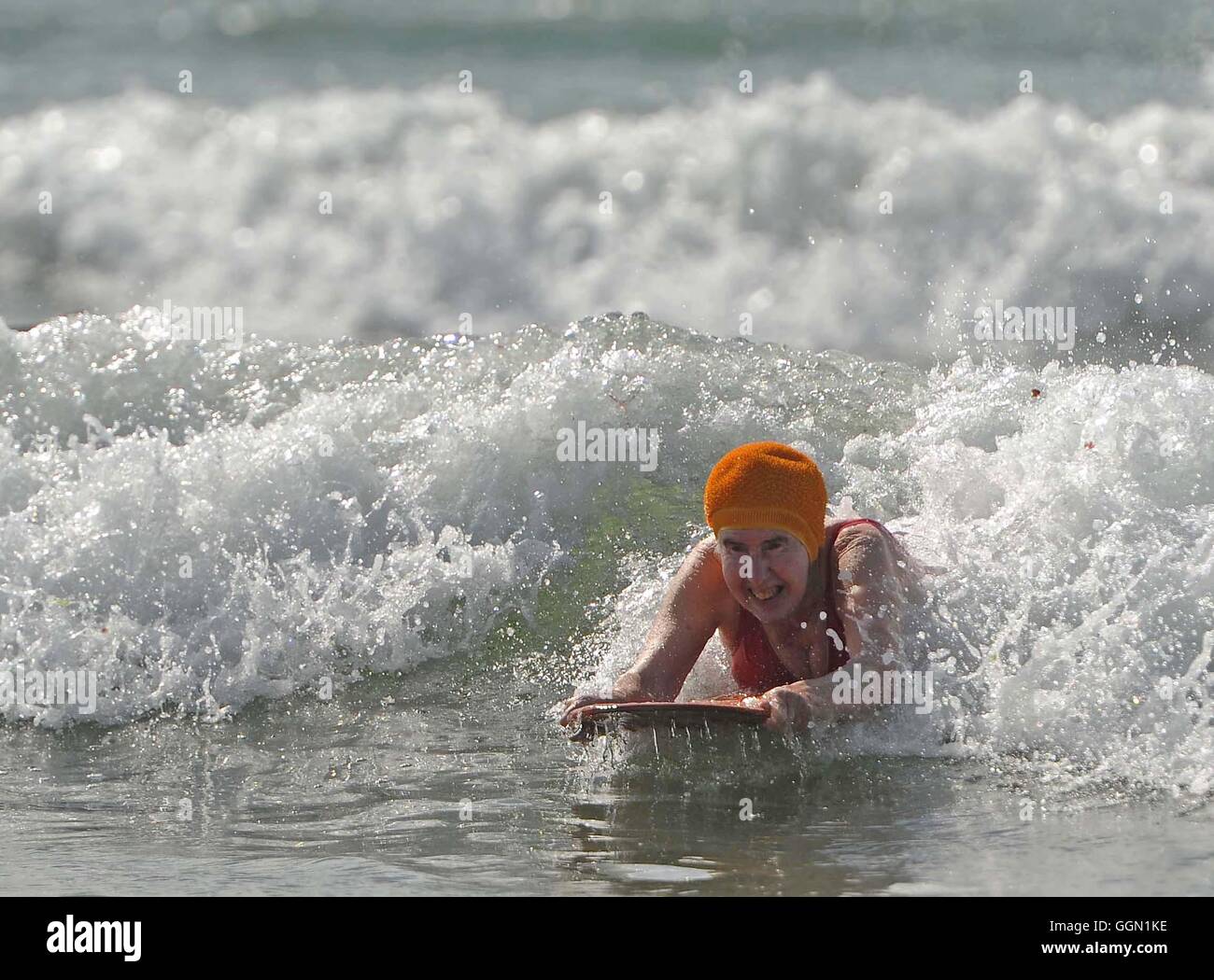 Elderly woman enjoys bodyboarding at Polzeath beach, Cornwall, UK Stock ...