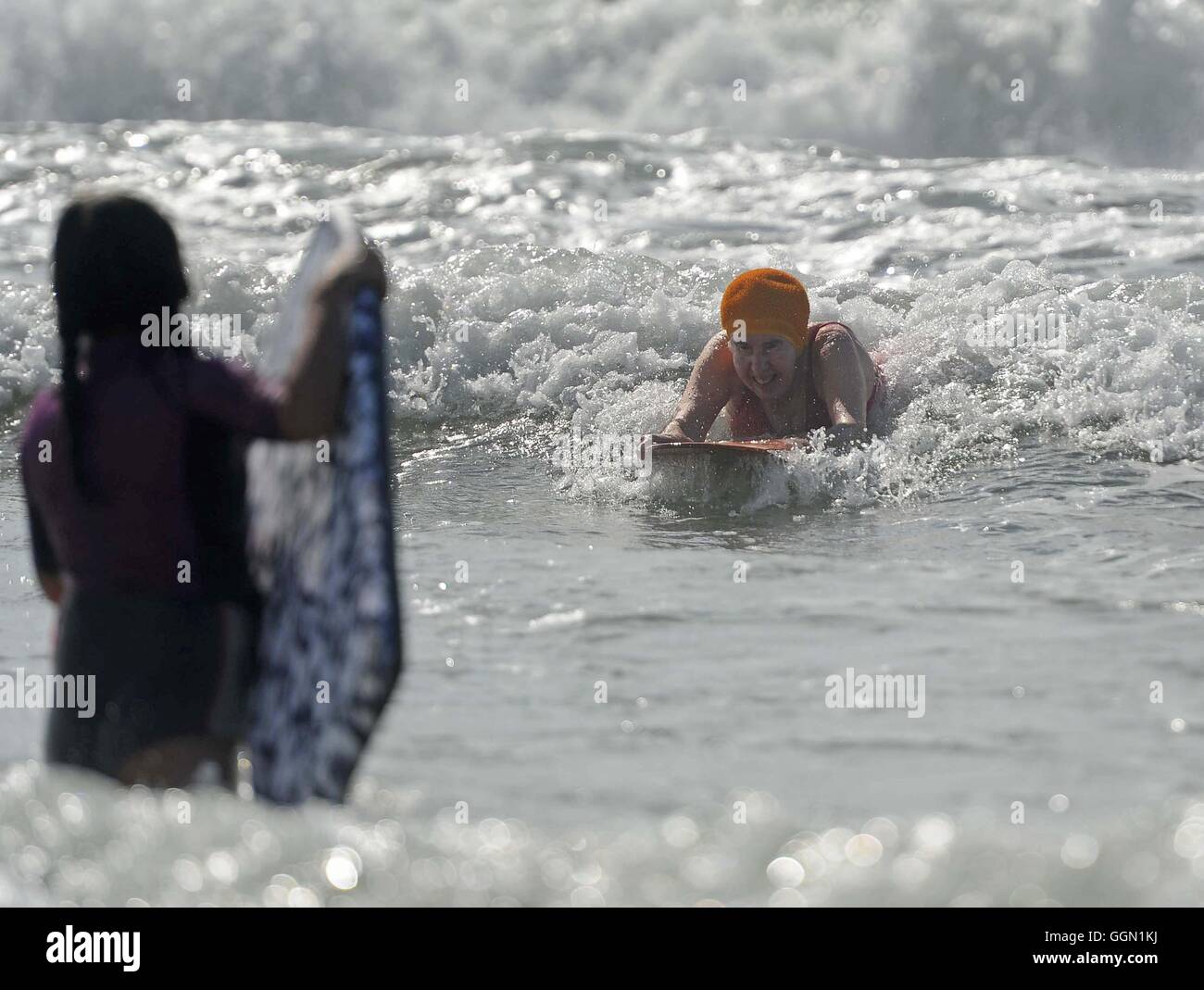 Elderly woman enjoys bodyboarding at Polzeath beach, Cornwall, UK Stock ...
