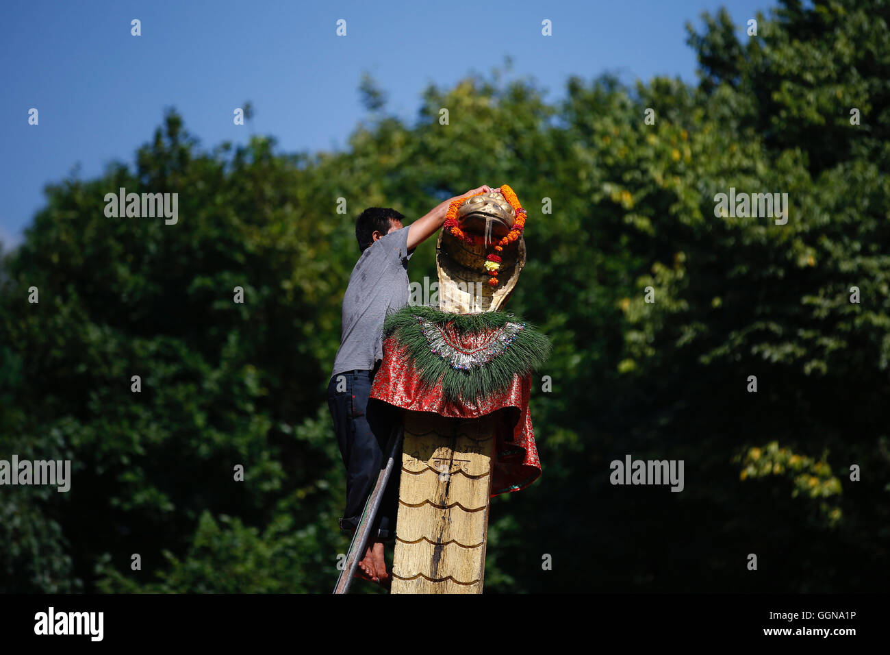 Kathmandu, Nepal. 7th Aug, 2016. A Nepalese priest placing garlands ...