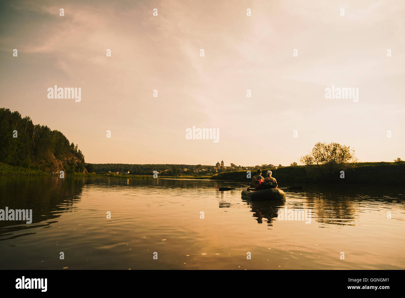 Caucasian family paddling boat on river Stock Photo - Alamy