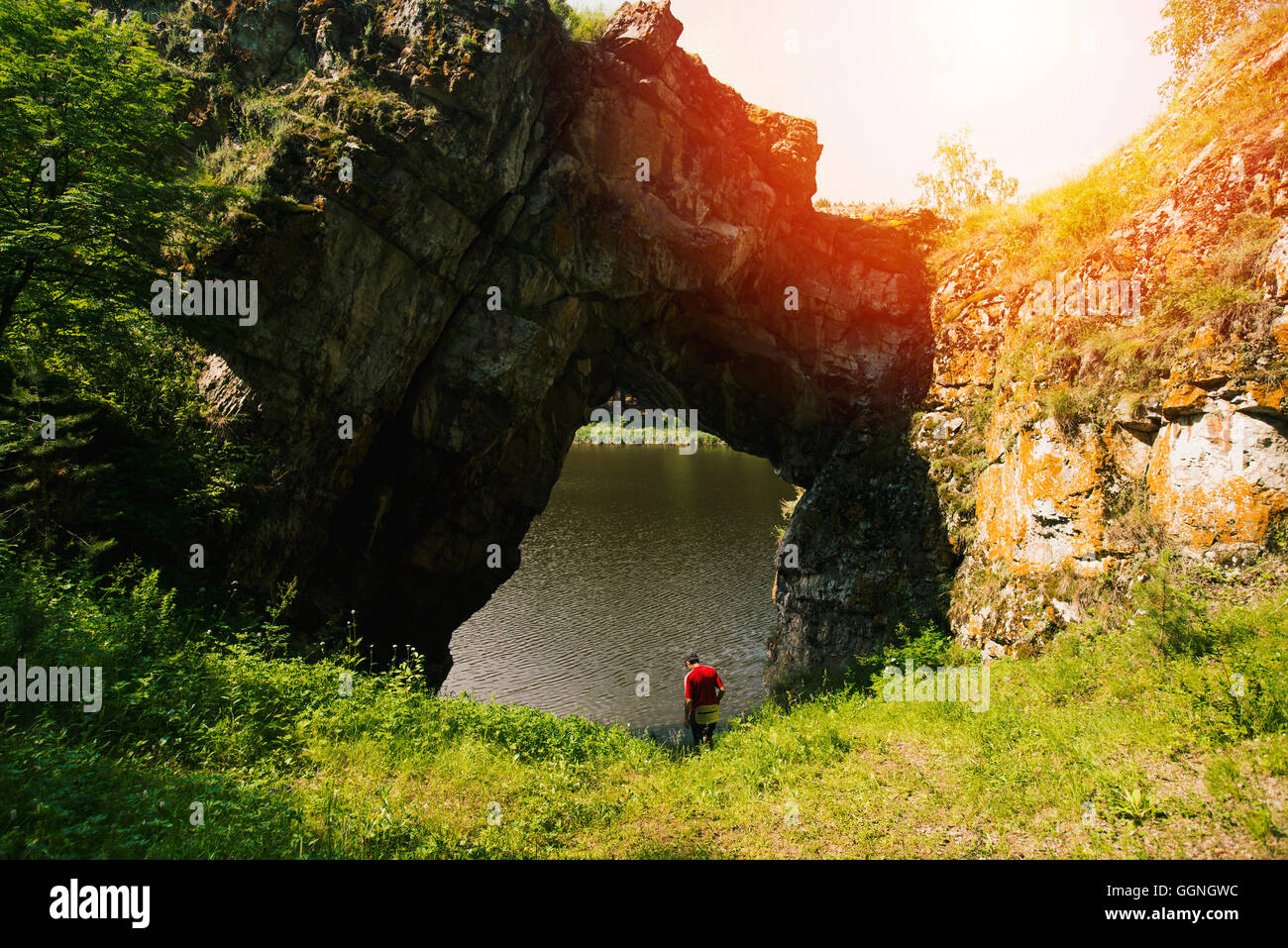 Caucasian man under rock formation arch Stock Photo - Alamy