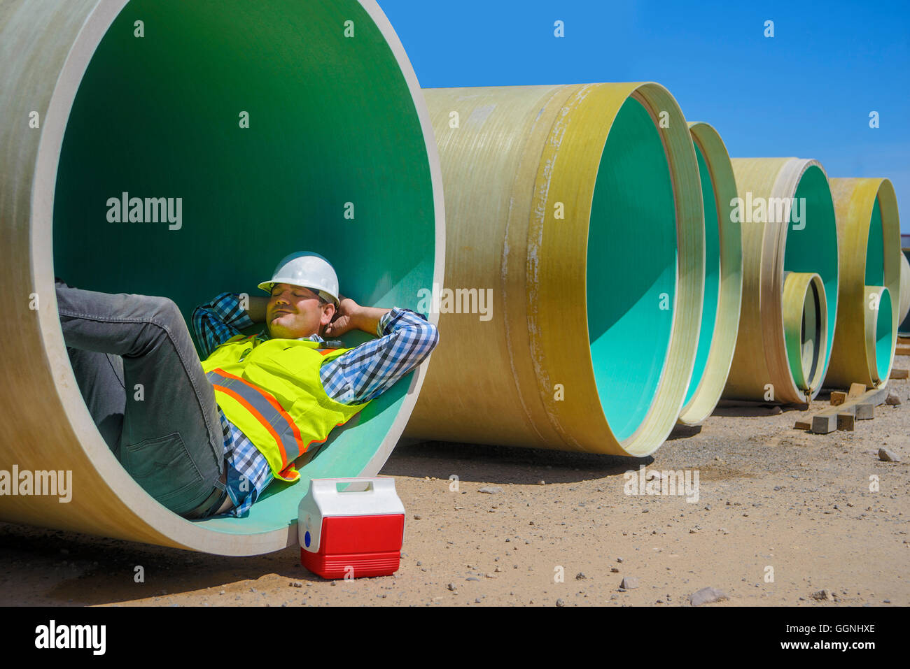Caucasian construction worker napping inside large pipe Stock Photo - Alamy
