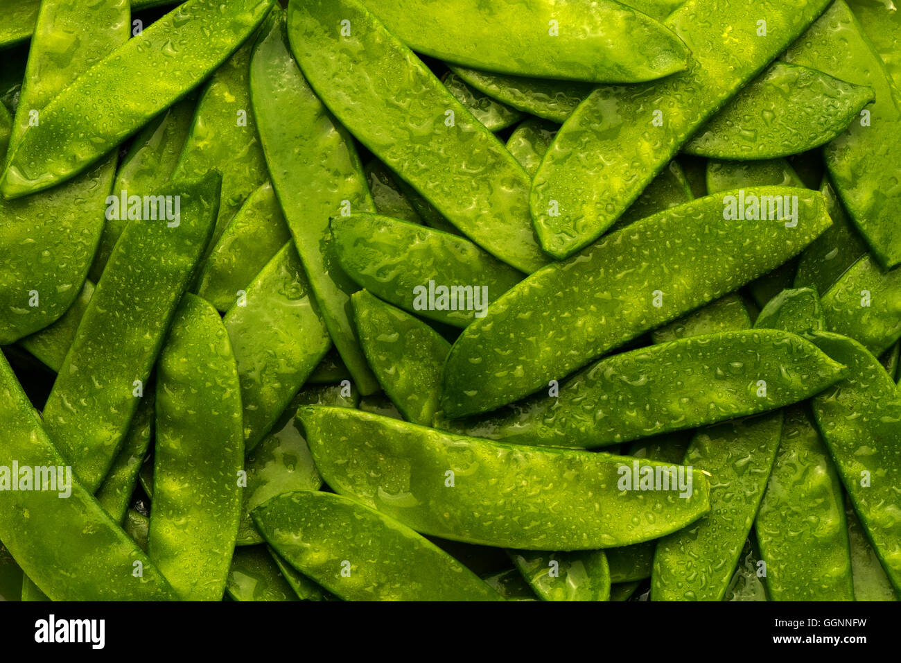 Pile of wet green peas in pods Stock Photo - Alamy
