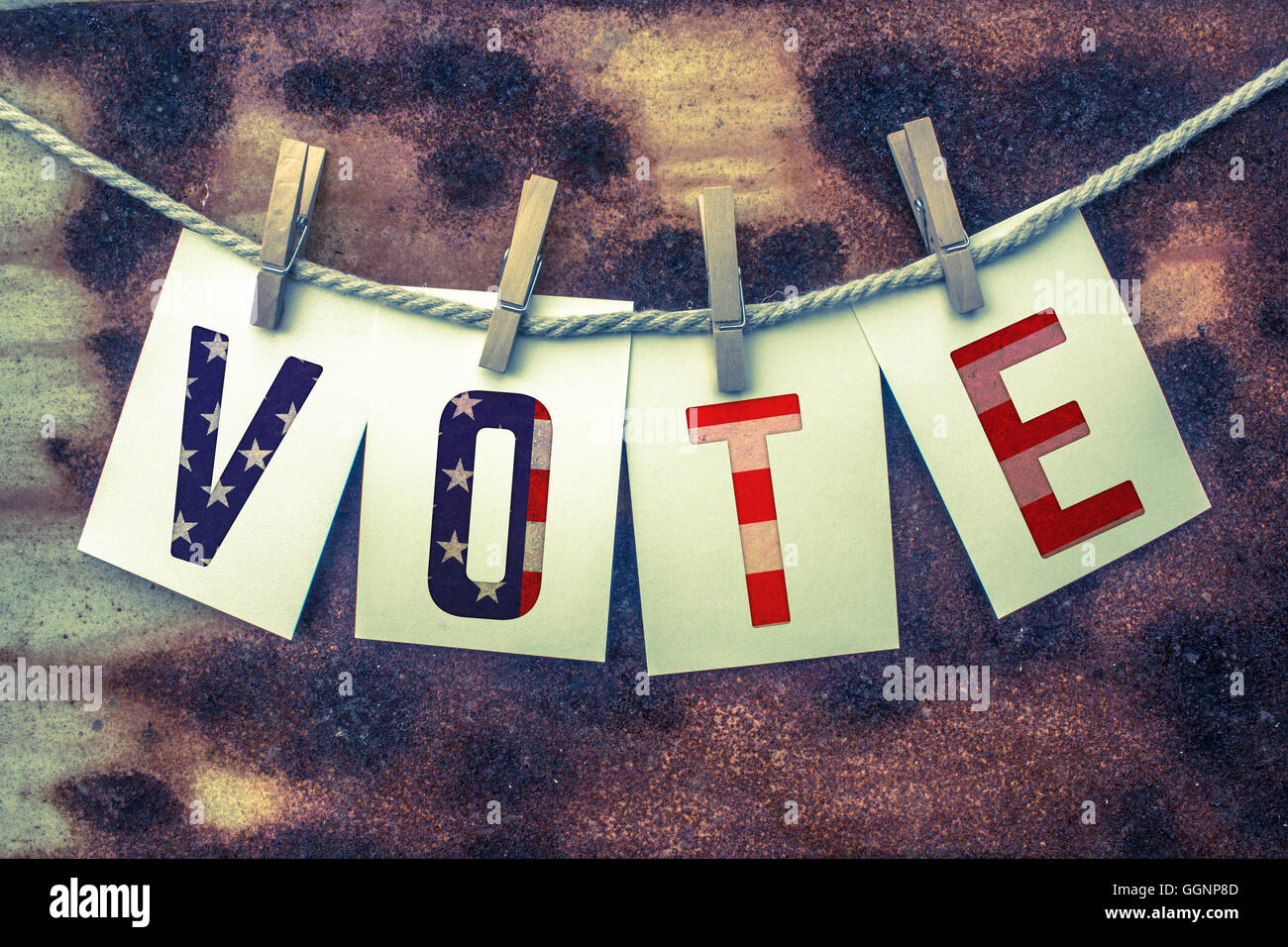 The word VOTE stamped on card stock hanging from old twine and clothes ...