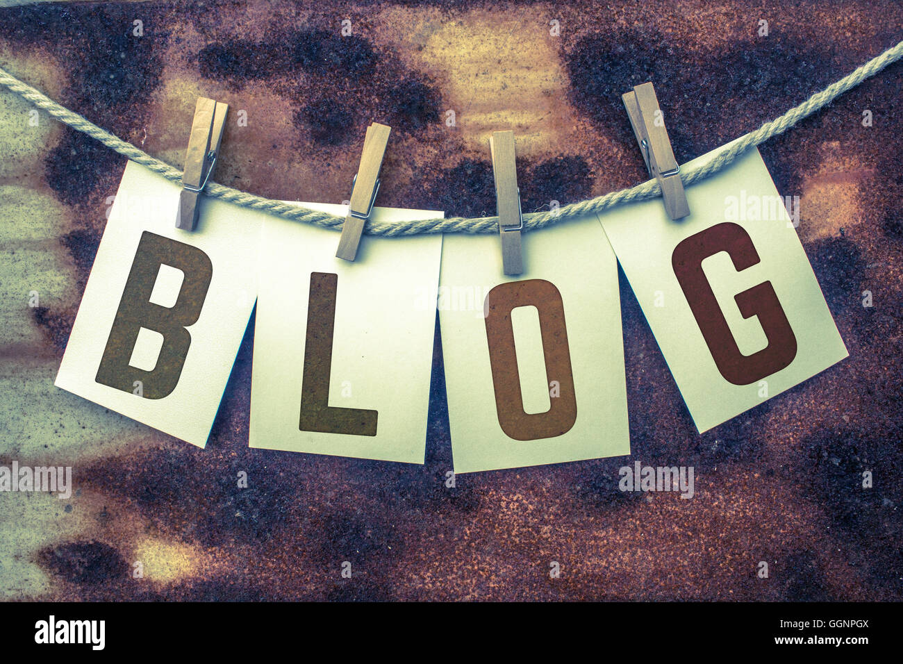 The word BLOG stamped on card stock hanging from old twine and clothes ...