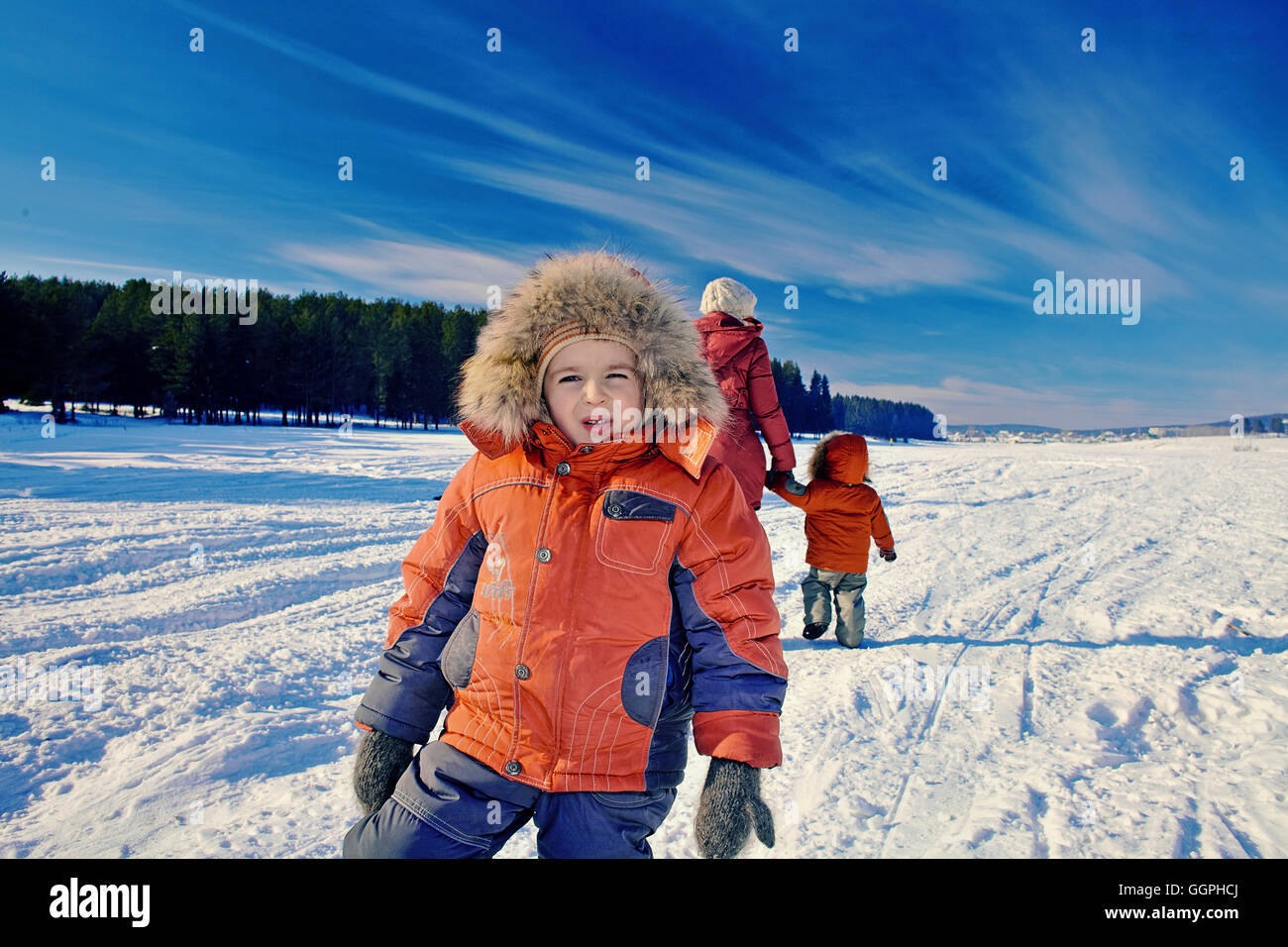 Mother and sons walking in snowy remote field Stock Photo - Alamy