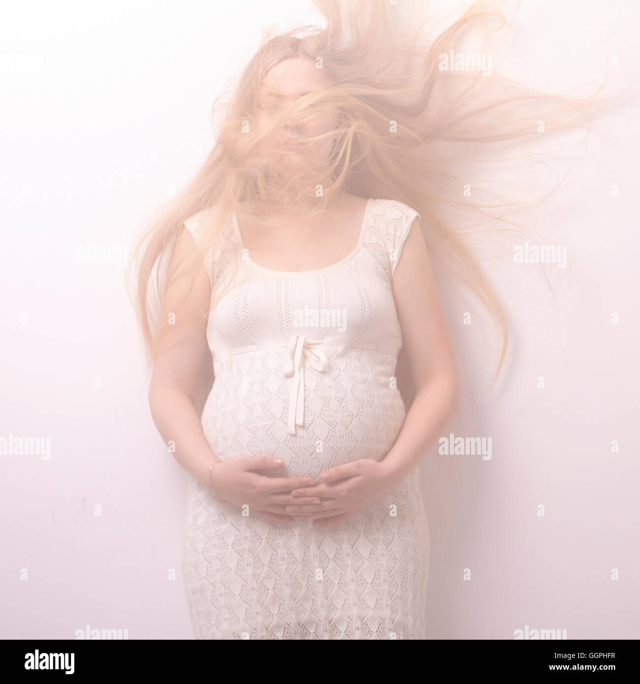 Pregnant woman with windblown hair Stock Photo - Alamy