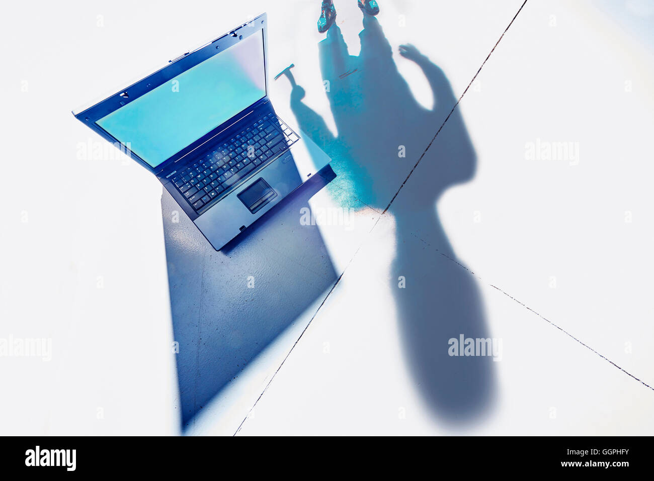 Shadow of hacker lurking over laptop computer Stock Photo - Alamy