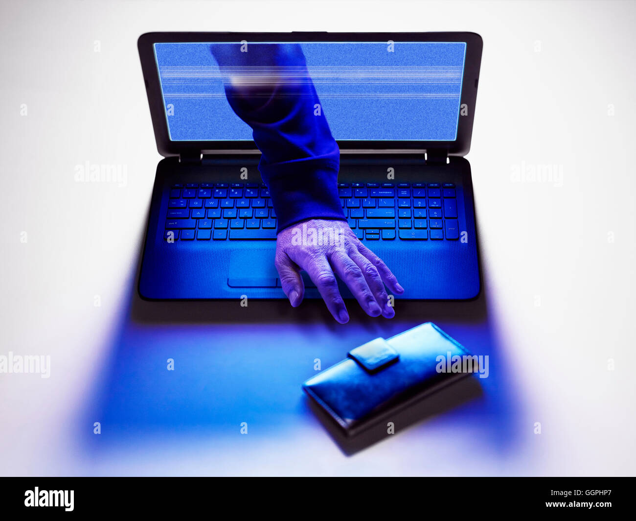 Hand of hacker reaching for wallet from screen of laptop Stock Photo ...