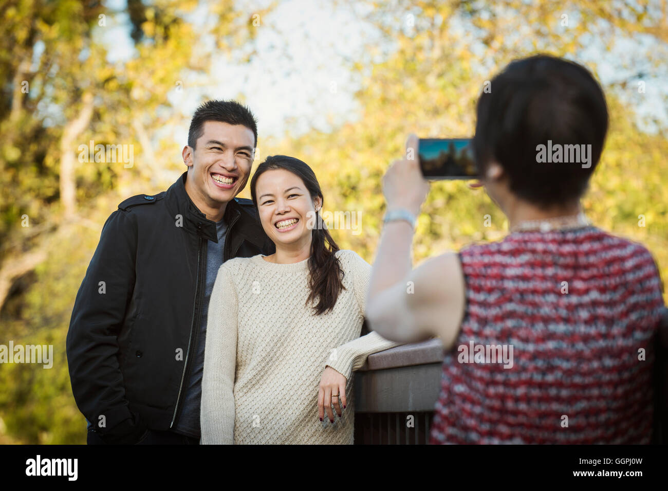 Chinese mother photographing adult offspring outdoors Stock Photo - Alamy
