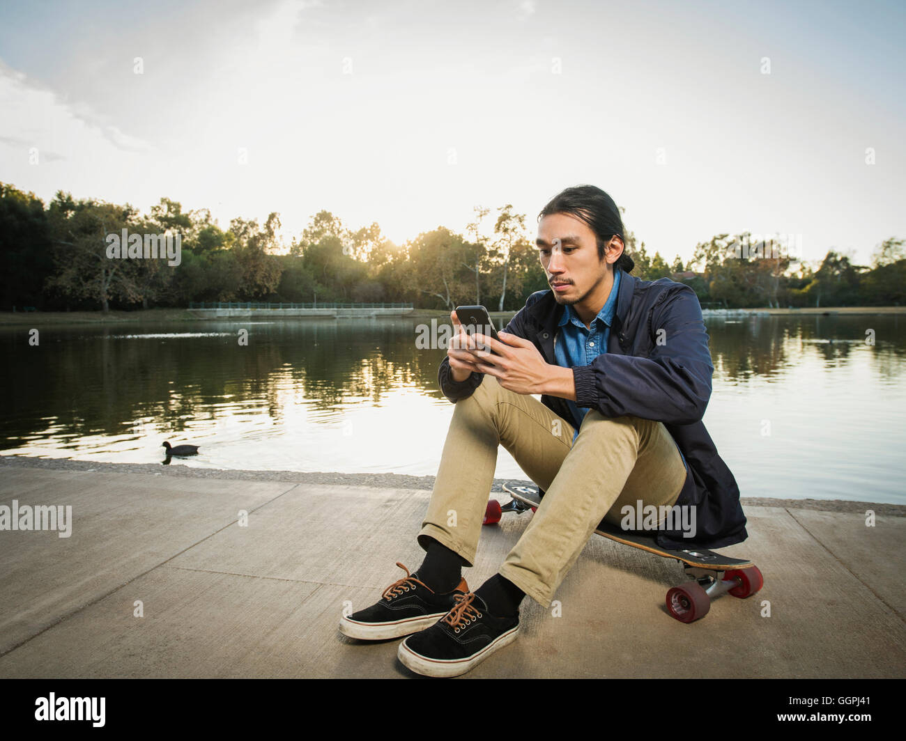 Chinese man using cell phone in park Stock Photo - Alamy