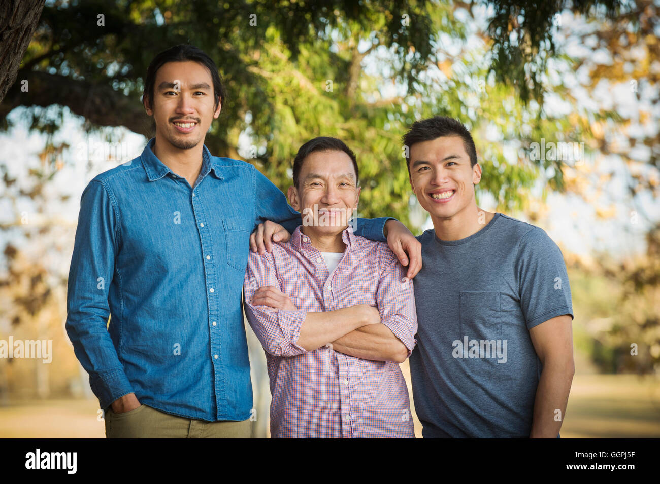 Chinese father and sons smiling outdoors Stock Photo - Alamy