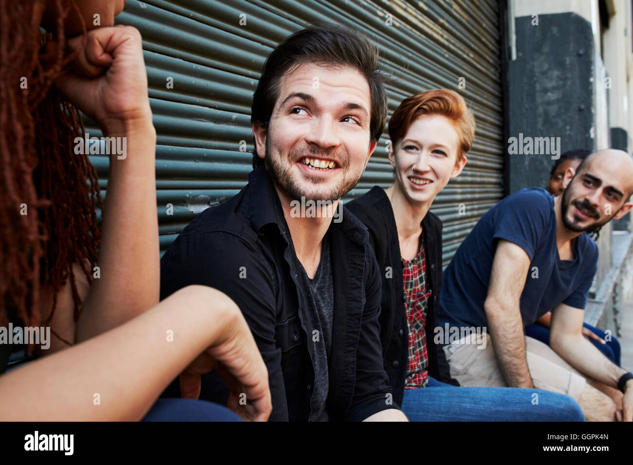 Friends talking on loading dock Stock Photo - Alamy