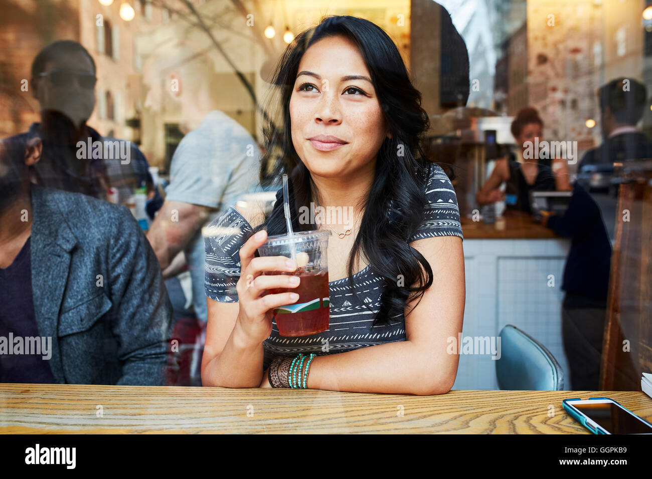 Mixed Race woman thinking in cafe window Stock Photo - Alamy